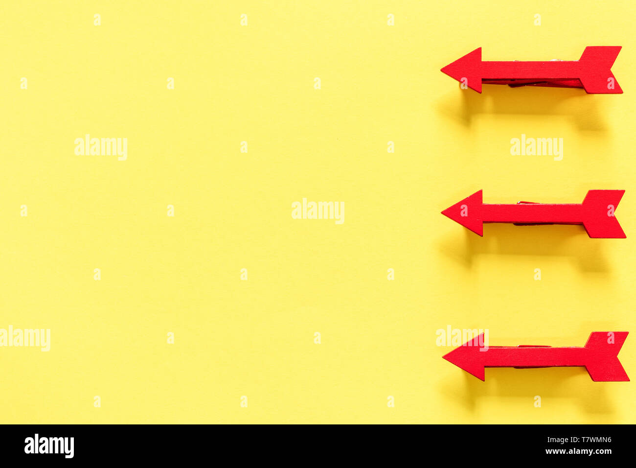 Three red arrow on bright yellow background, top view Stock Photo - Alamy
