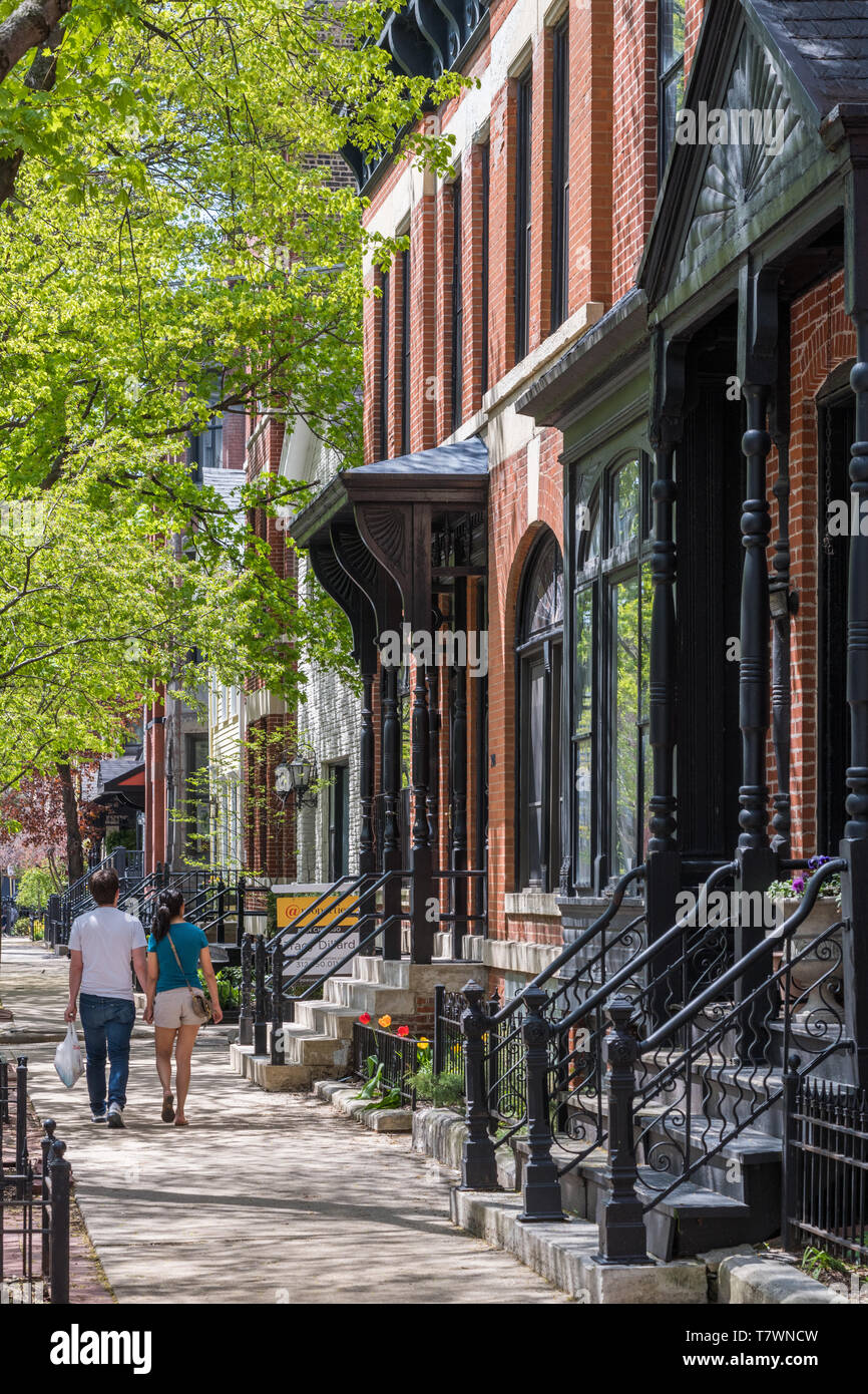Couple holding hands walking down a tree lined residential street in ...