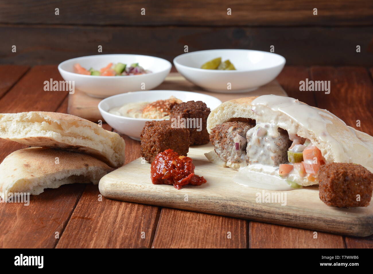 Falafel in pita bread with vegetable salad, harissa sauce, humus ...