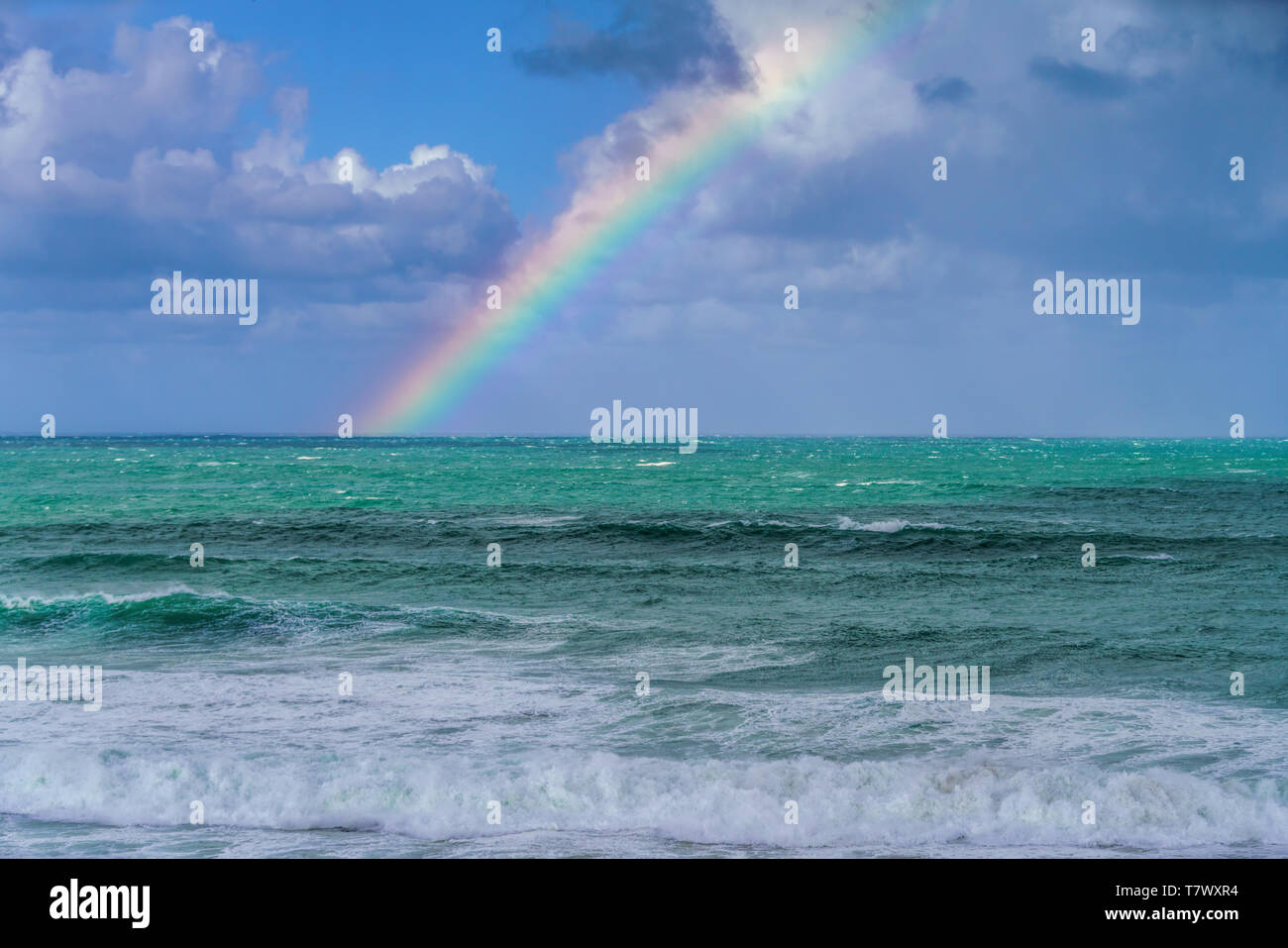 Rainbow in the ocean after rain and thunderstorms. Colorful views of ...