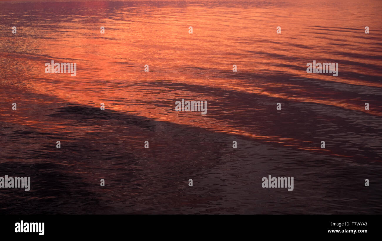 Little wave ripples on a water surface in red sunset colours Stock ...