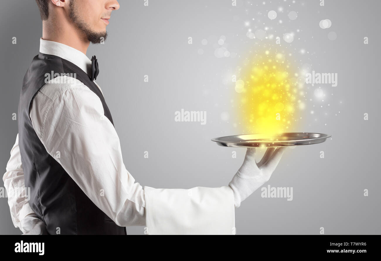 Elegant young waiter serving mysterious light on tray Stock Photo - Alamy