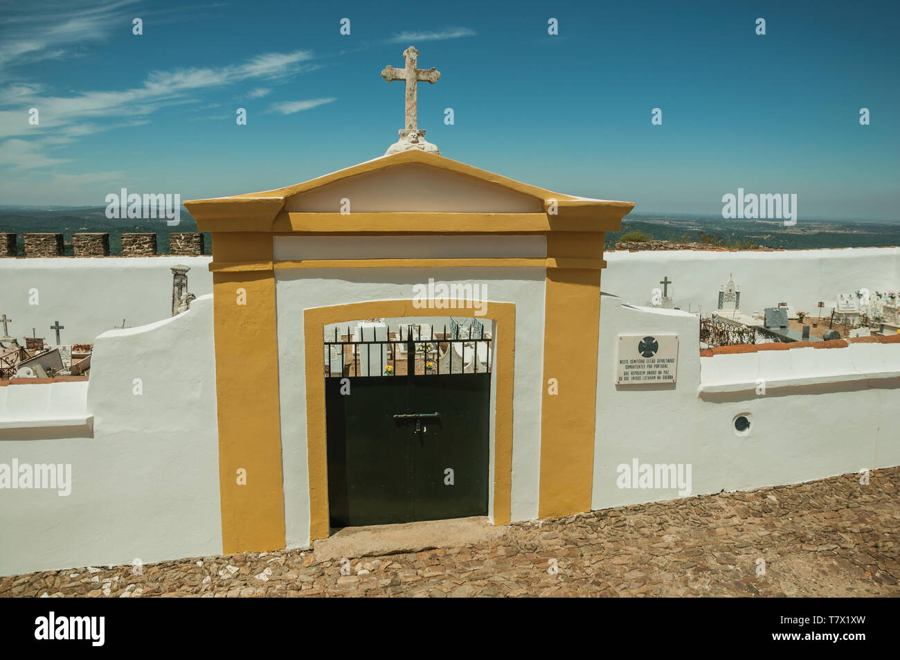 Colorful gateway in graveyard wall on the main street of Evoramonte. A ...