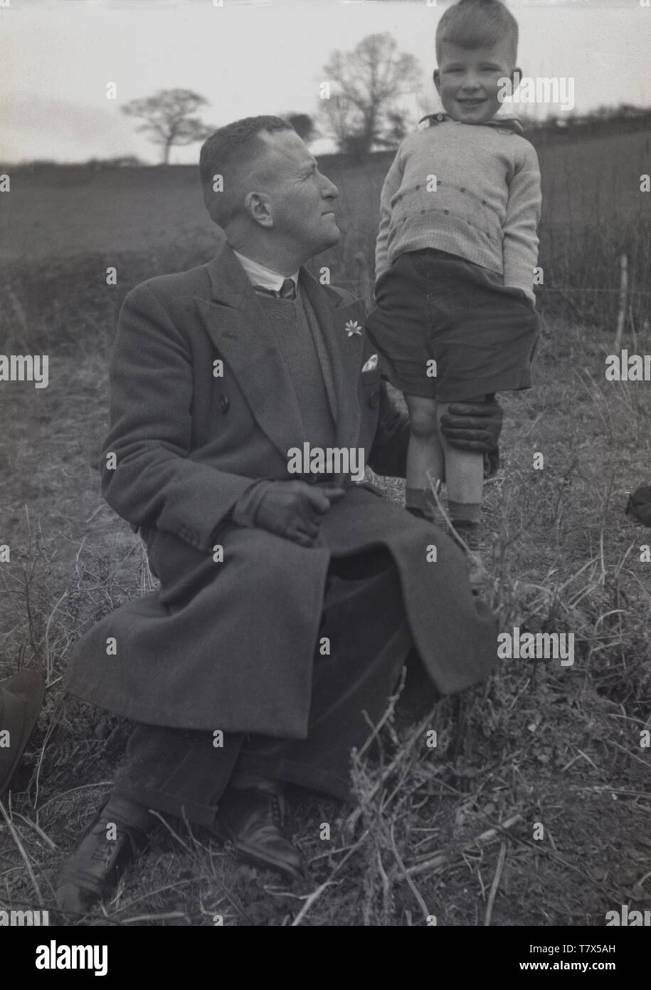 1950s, historical, a proud father with his young boy sitting outside on ...