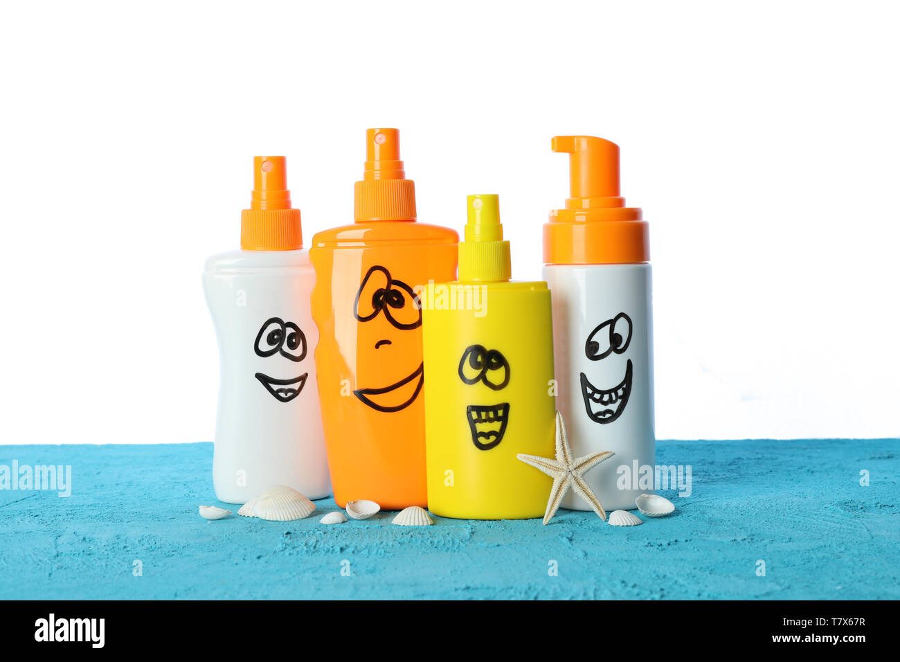 Happy sunscreen sprays with starfish and seashells on color table ...