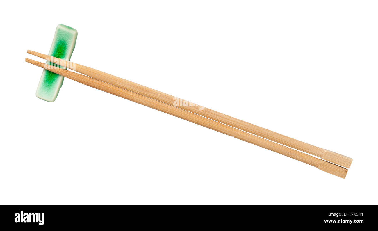 top view of beech wooden chopsticks served on chopstick rest isolated ...