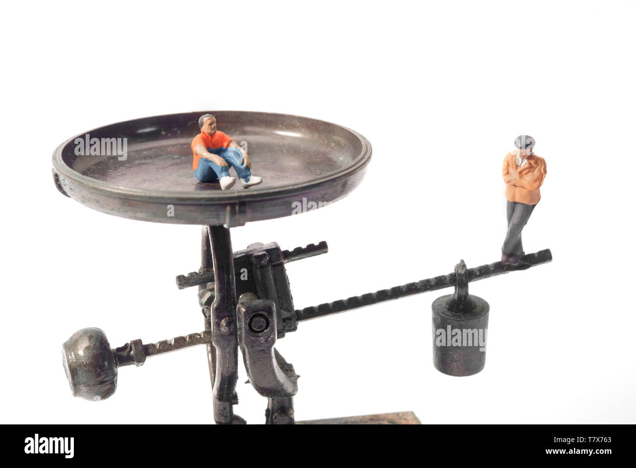 View of miniature toy people sit on scales Stock Photo - Alamy