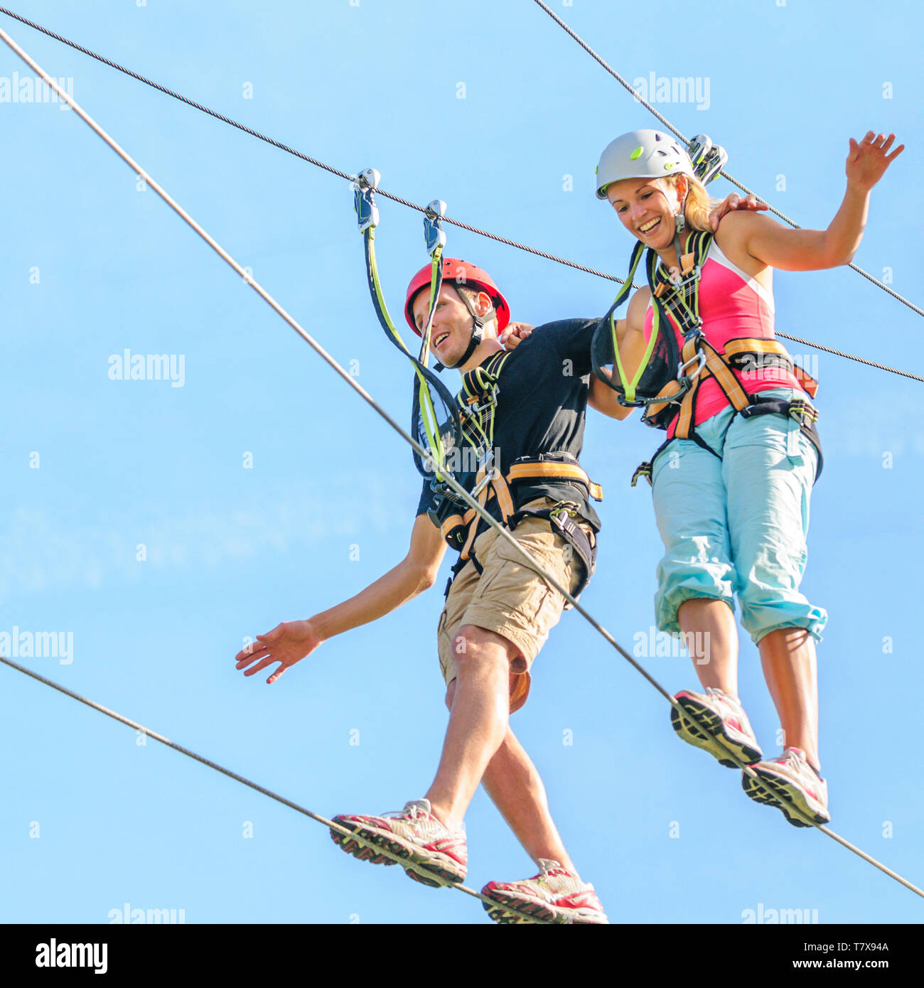 Partner exercise in high rope course, couple absolving difficult ...