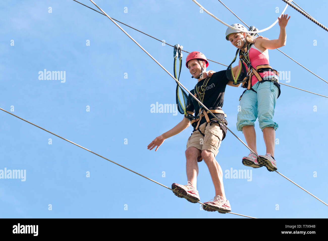 Partner exercise in high rope course, couple absolving difficult ...