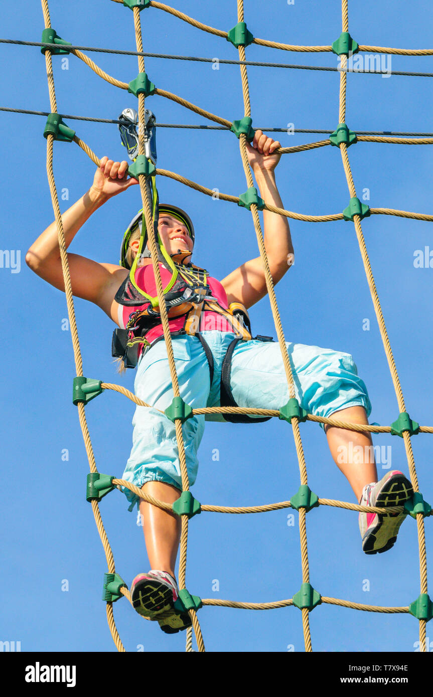 Young woman doing exercises in high rope course at a sunny day Stock ...