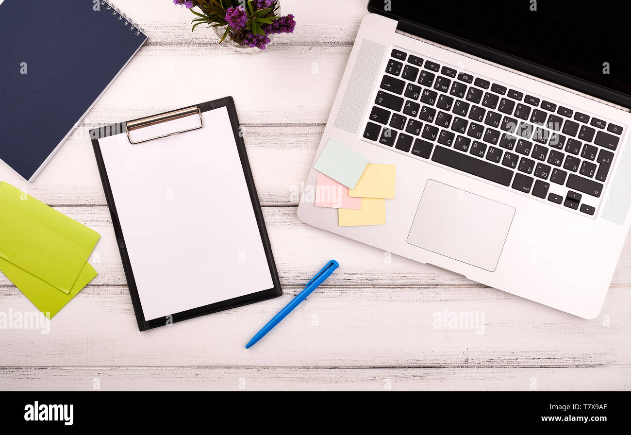 Planner on the wooden working table with computer. Blank white paper on ...