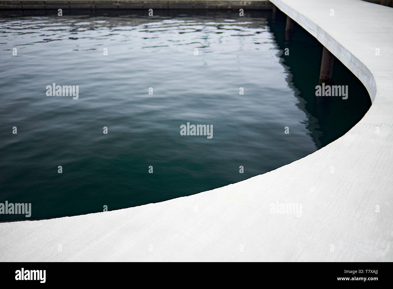 Abstract rounded bridge across river Stock Photo - Alamy