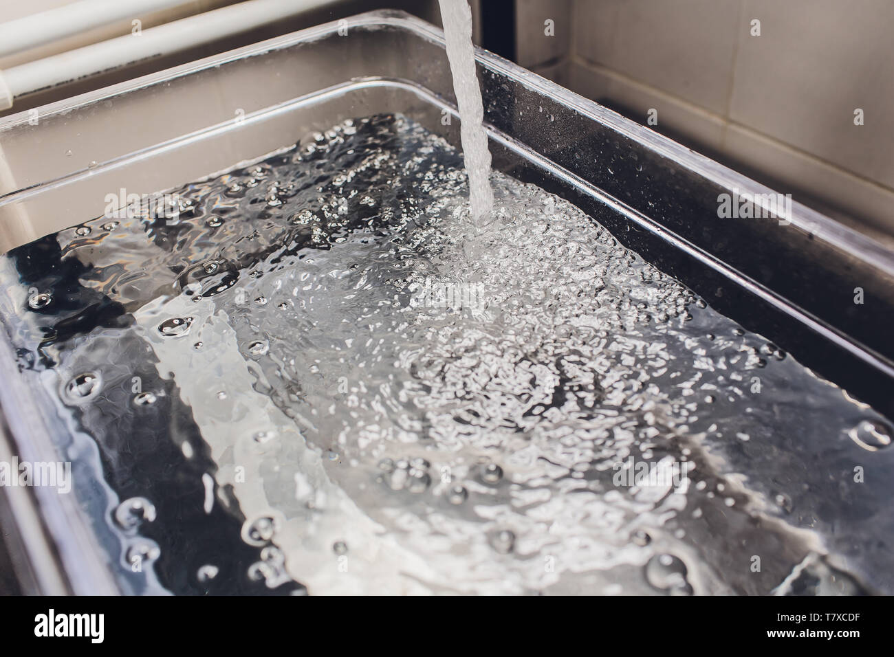 Tableware in sink Washing tableware in sink with water Stock Photo - Alamy
