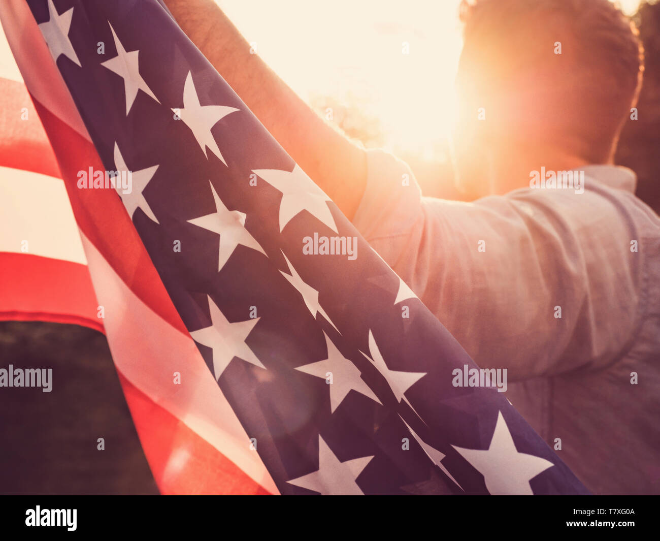 Handsome, young man waving an American flag Stock Photo - Alamy
