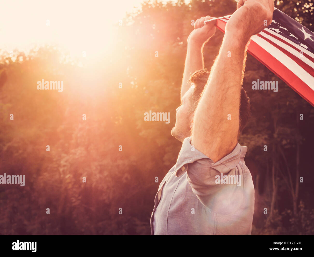 Handsome, young man waving an American flag Stock Photo - Alamy