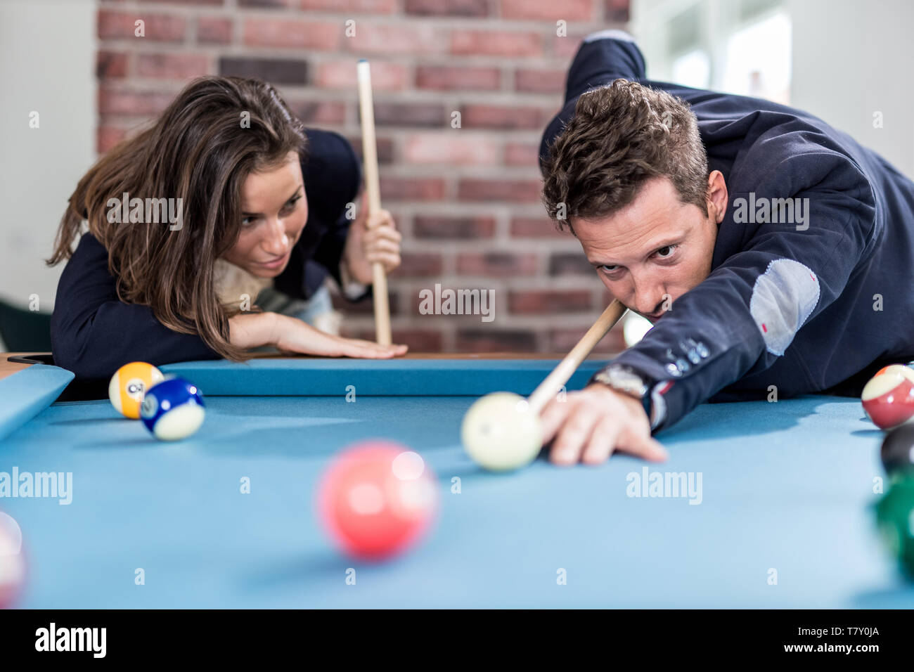 Young modern couple playing pool table billiard game Stock Photo - Alamy
