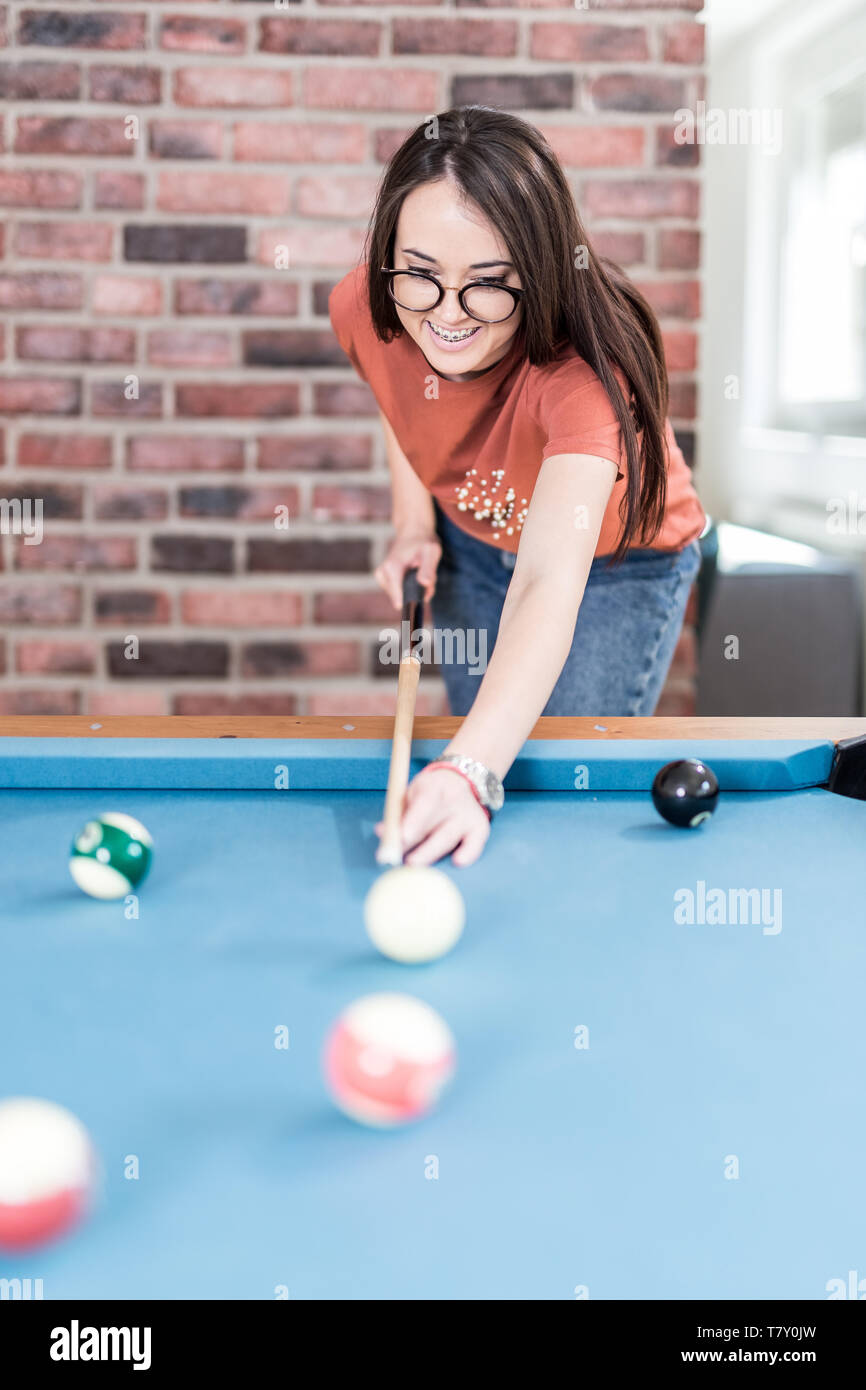 Fashionable urban woman playing pool table billiards game Stock Photo ...