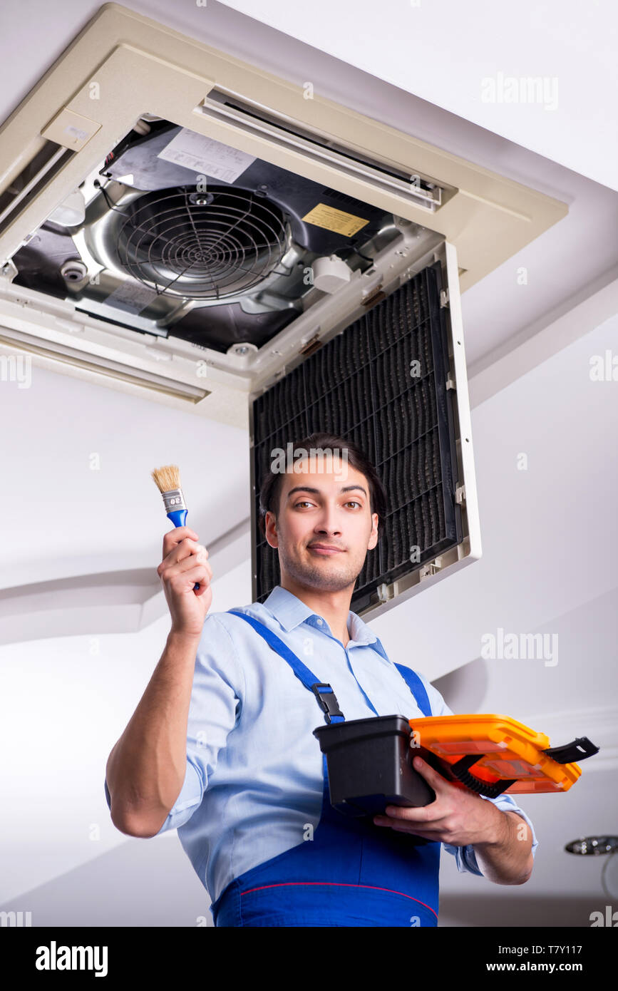 Young repairman repairing ceiling air conditioning unit Stock Photo - Alamy