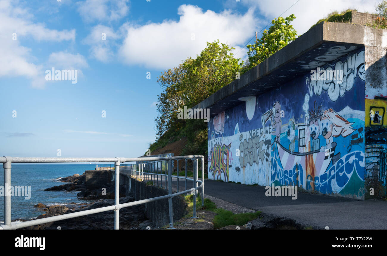 Disused railway halt covered with graffiti in seaside location, between ...