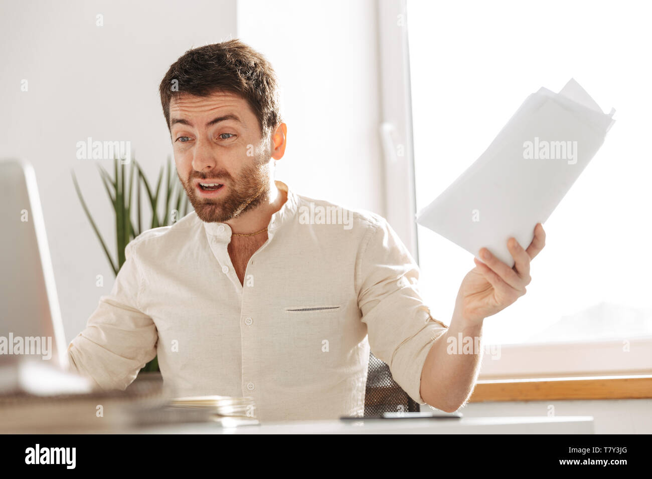 Image of frustrated office worker 30s wearing white shirt using laptop ...