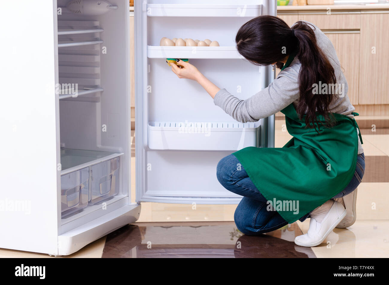 Young woman cleaning fridge in hygiene concept Stock Photo - Alamy