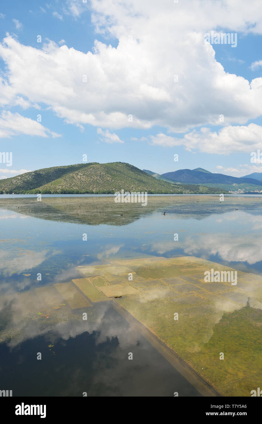 Submerged pier in calm lake with clouds reflections Stock Photo - Alamy