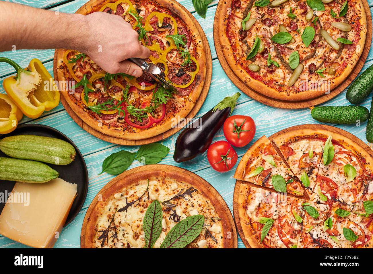 italian pizza set at blue wooden background. chef cuts pizza. italian ...