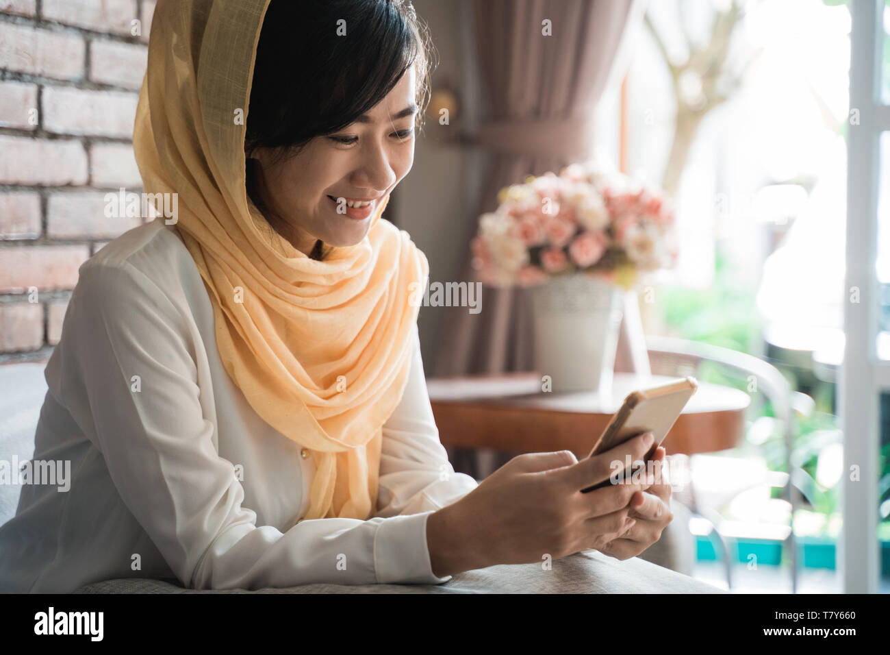 muslim woman using mobile phone at home sitting Stock Photo - Alamy