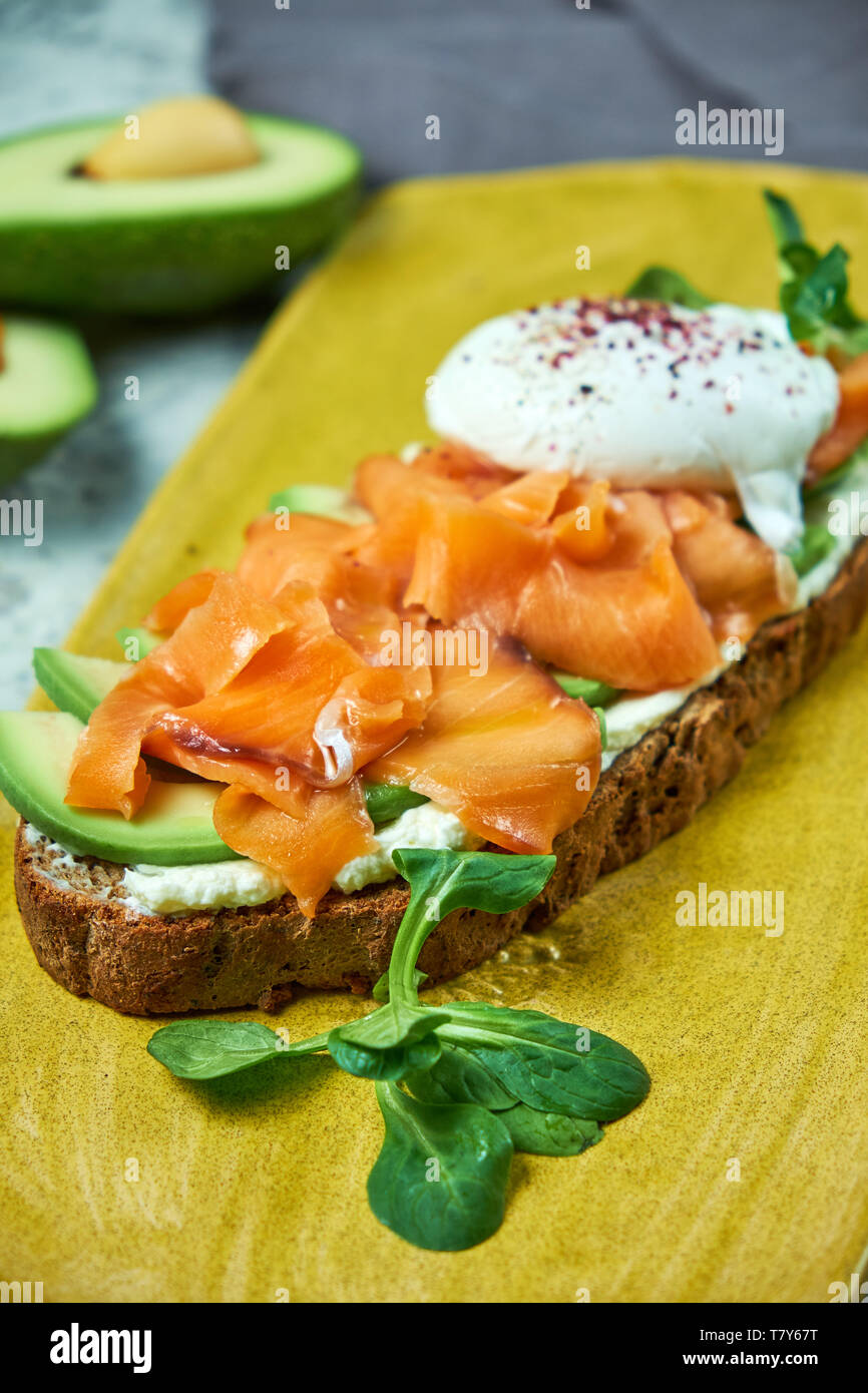 On a yellow plate of bruschet with salmon, next to it is a slice of ...