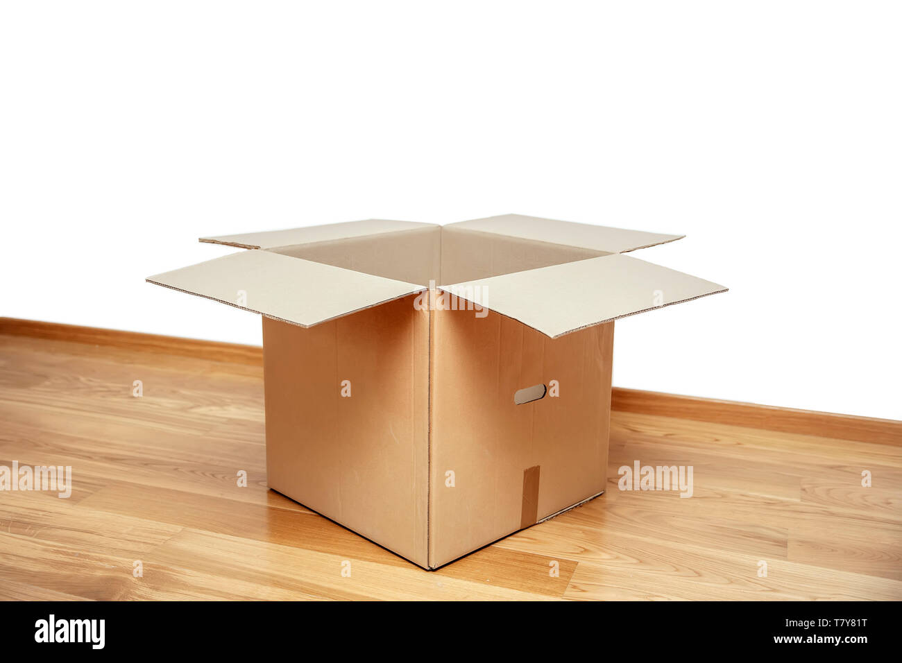 Open cardboard box on the floor in empty room, ready for transport ...