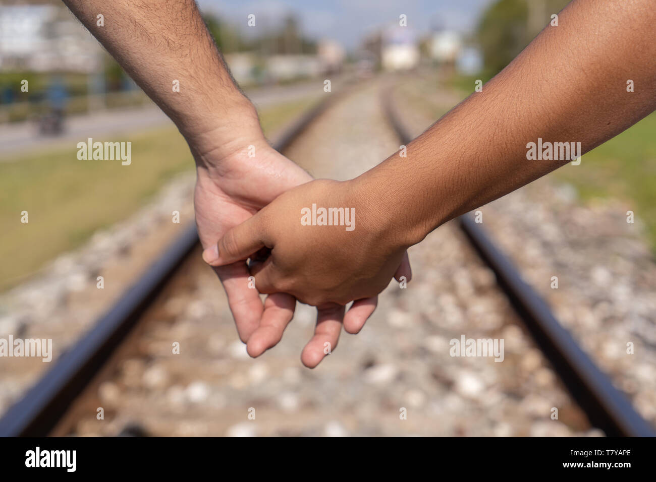 Given hands of two people on the train line Stock Photo - Alamy