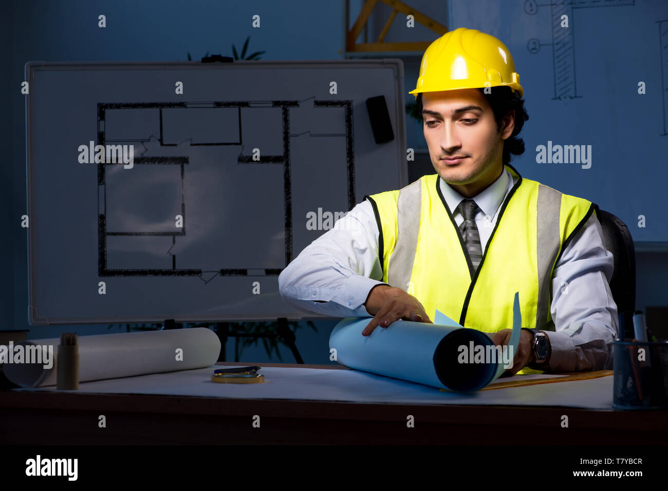 Young construction architect working on project at night Stock Photo ...