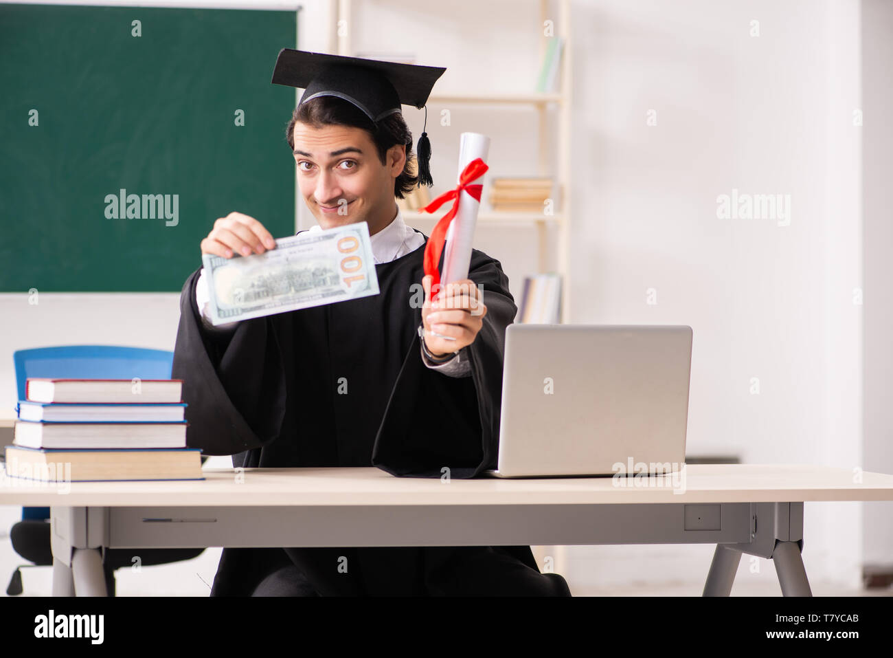 Graduate student in front of green board Stock Photo - Alamy