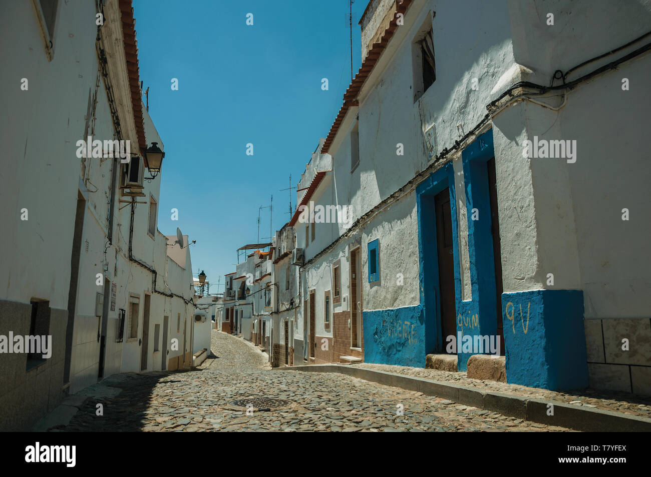 Old colorful houses with rough plaster in an alley of Campo Maior. A ...