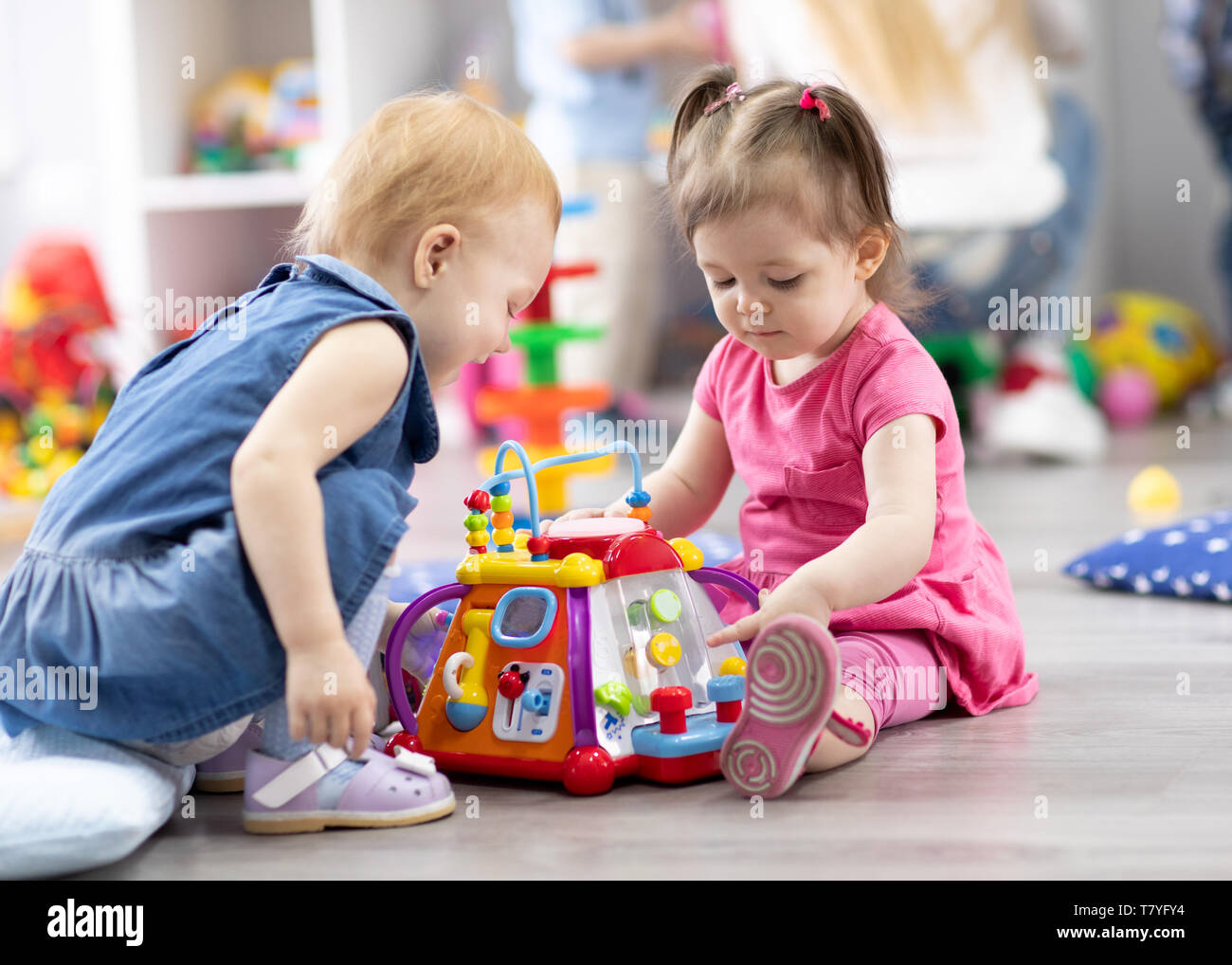 children toddlers girls play together educational toys in playroom ...