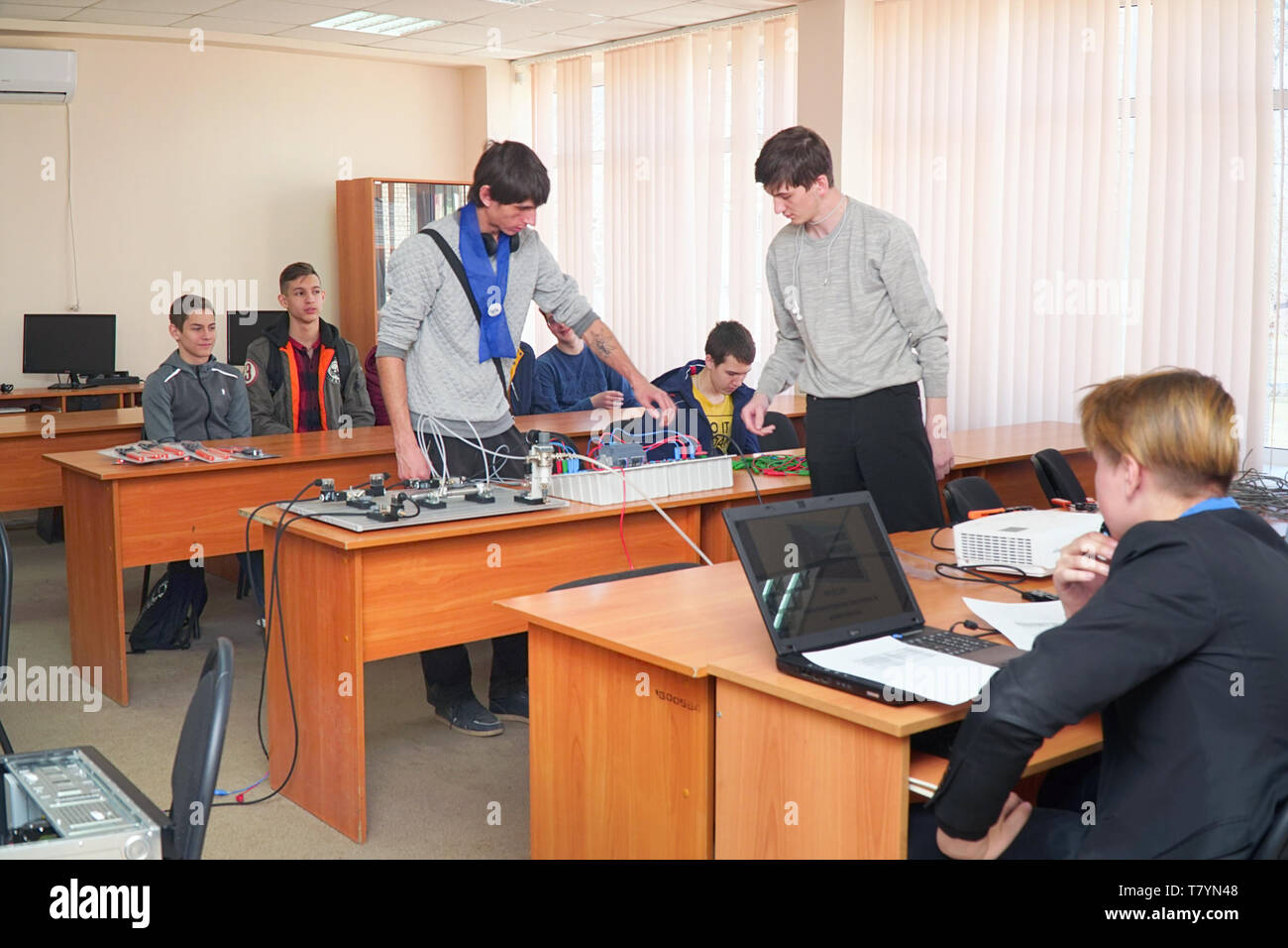 Students connect wires control panel with small test bench for ...