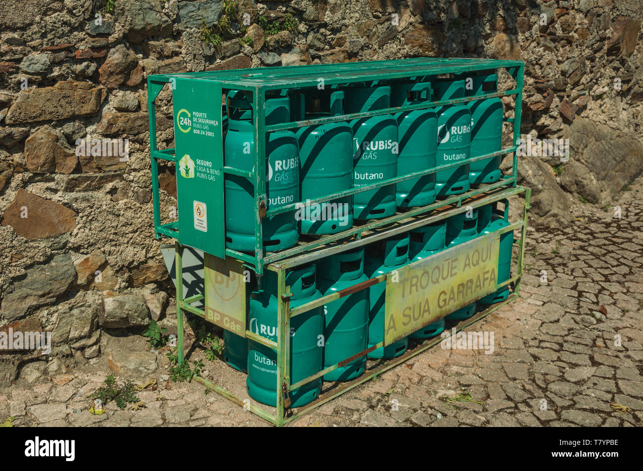 Butane gas canisters ready to be sold, inside iron cage on sunny day at ...