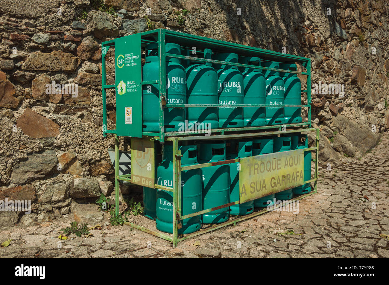Butane gas canisters ready to be sold, inside iron cage on sunny day at ...