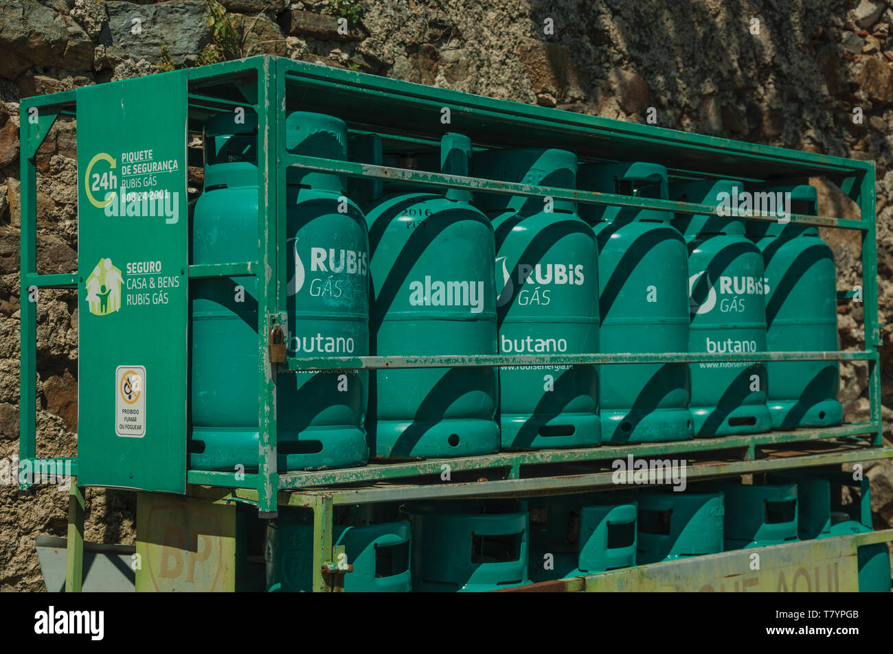 Butane gas canisters ready to be sold, inside iron cage on sunny day at ...