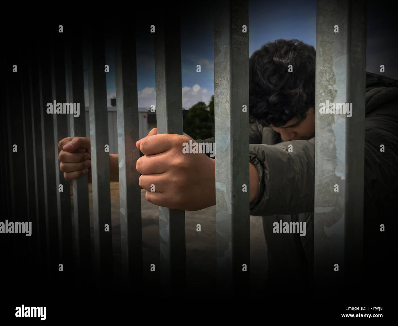 Teenager boy hands holding strong iron bars. Immigrant and refugee ...