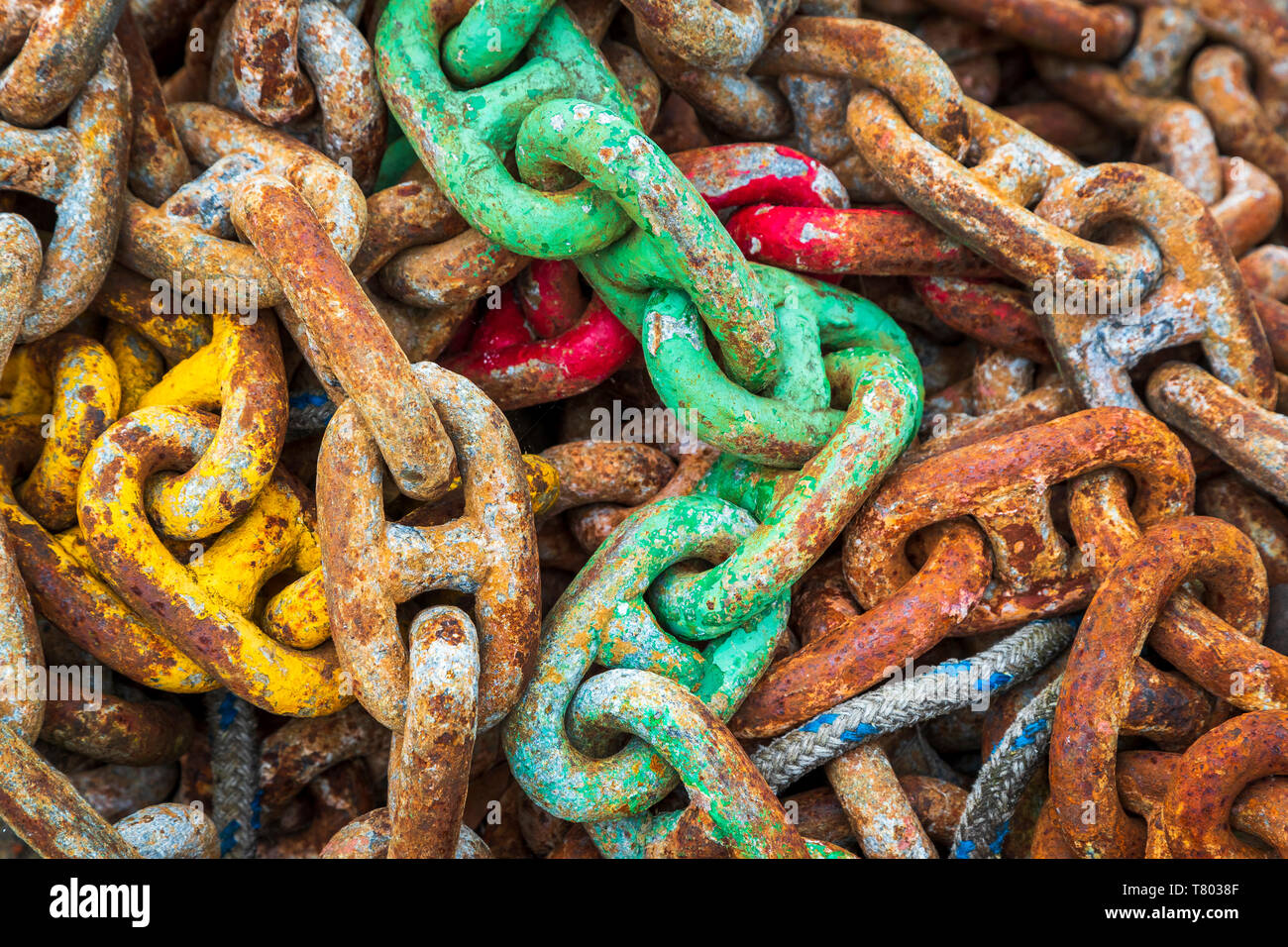Old rusty industrial heavy duty chains lying at a workplace near a ...