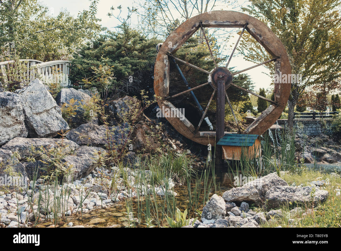 Water wooden old wheel mill in country village near pond stream. Retro ...