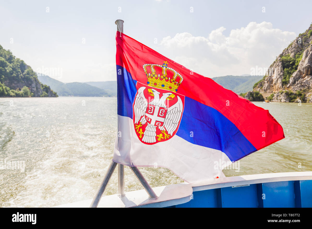Serbia national flag on tourist boat , Danube river landscape and sky ...