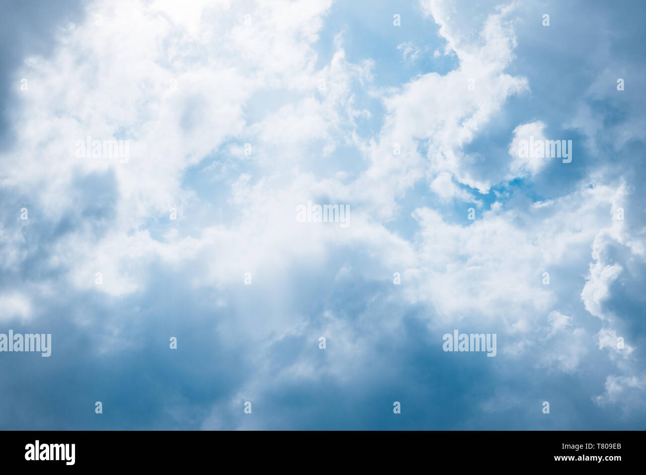 Dark blue sky with white grey clouds. Dramatic view of sun light beams ...