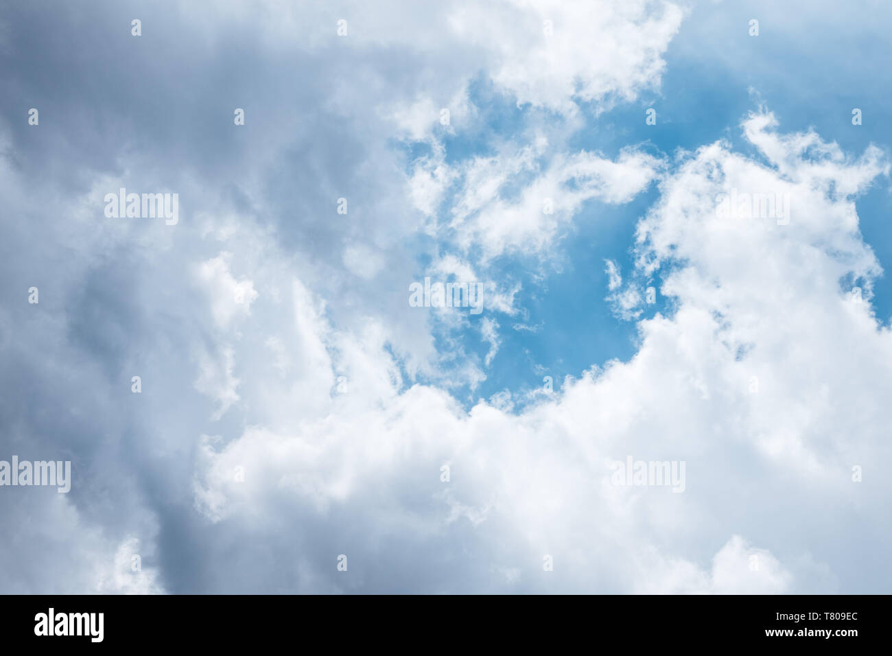 Dark blue sky with white grey clouds. Dramatic view of sun light beams ...