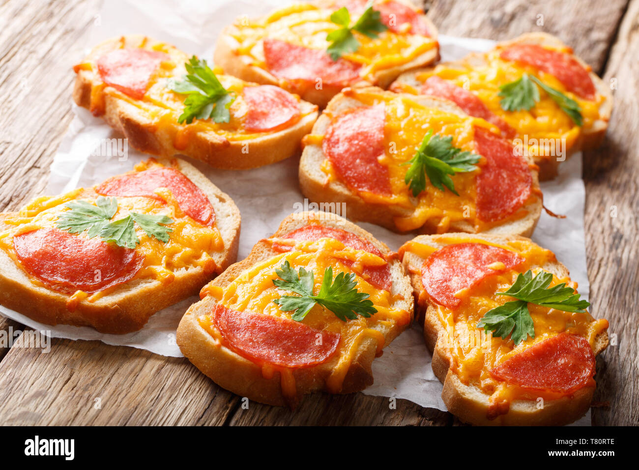 Homemade hot toasts with sausage and melted cheddar cheese close-up on ...