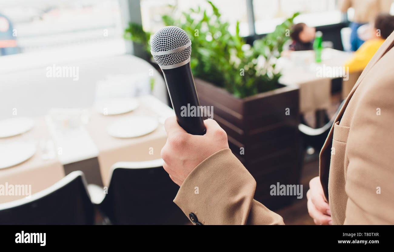 blurred of businessman hand holding microphone for speech presentation ...