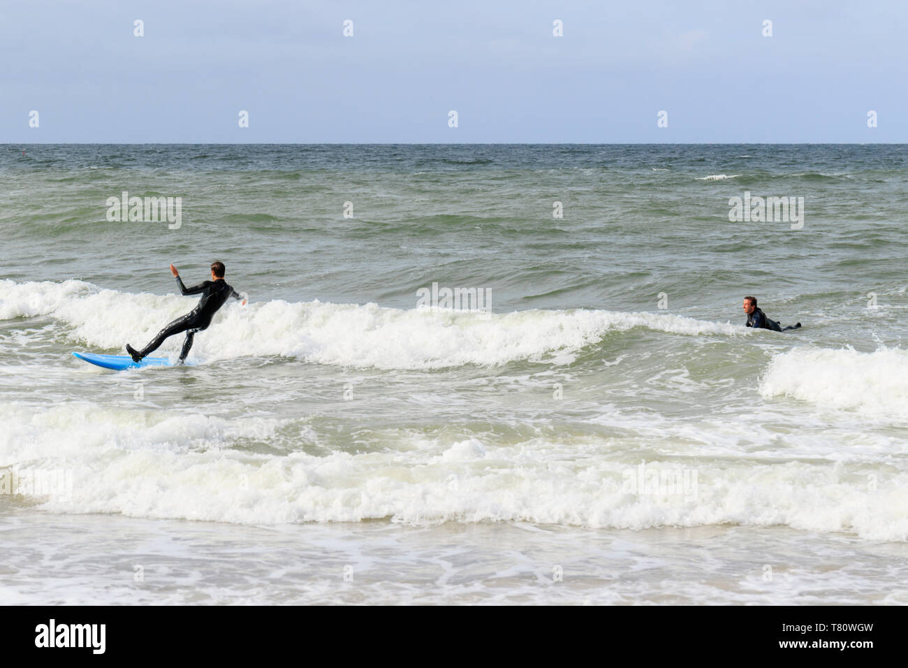 Surf boarders surfing of the North Norfolk coast UK, one surfer about ...