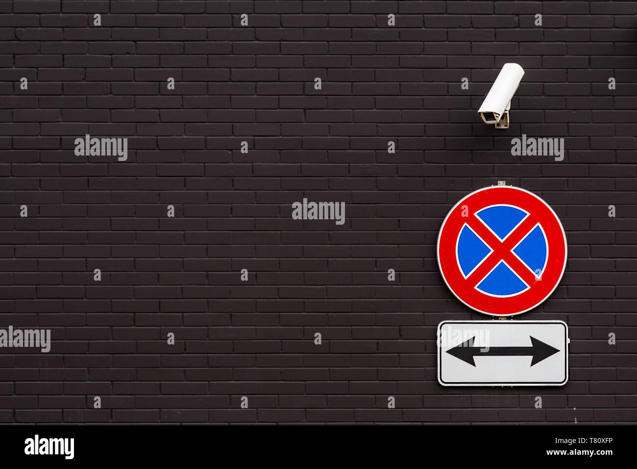 Modern surveillance camera and road signs on the wall of an office ...