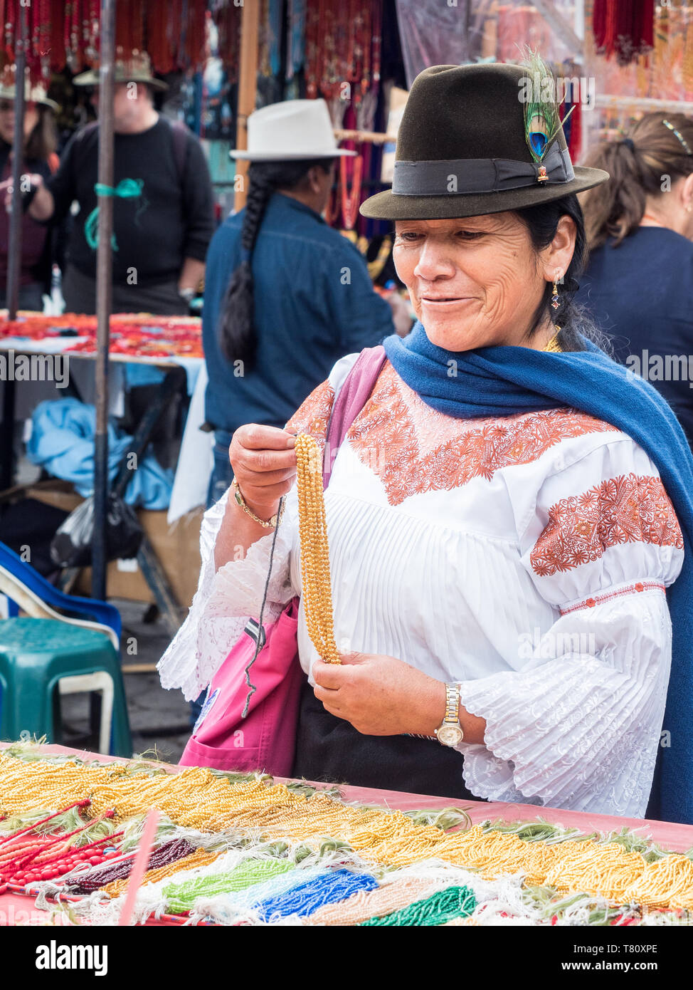 Indigenous woman buying gold necklace, market, Plaza de los Ponchos ...